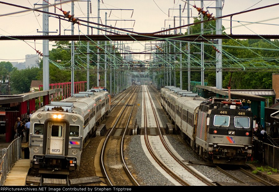 NJT 4411 is departing to head east and into NYP while NJT 6073 is arriving after leaving NYP.